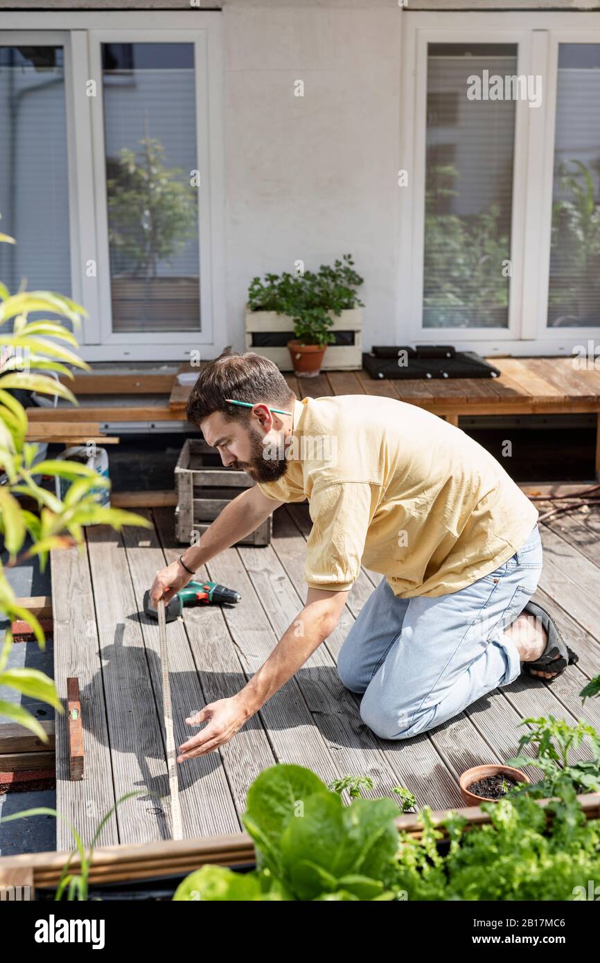 Young handyman building wood terrace in front of his home Stock Photo ...