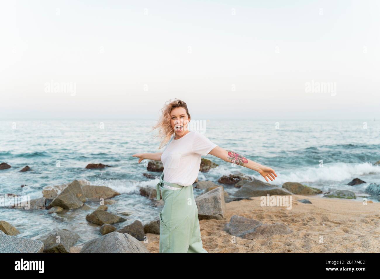 Young woman spending a day at the seaside, having fun on the beach ...
