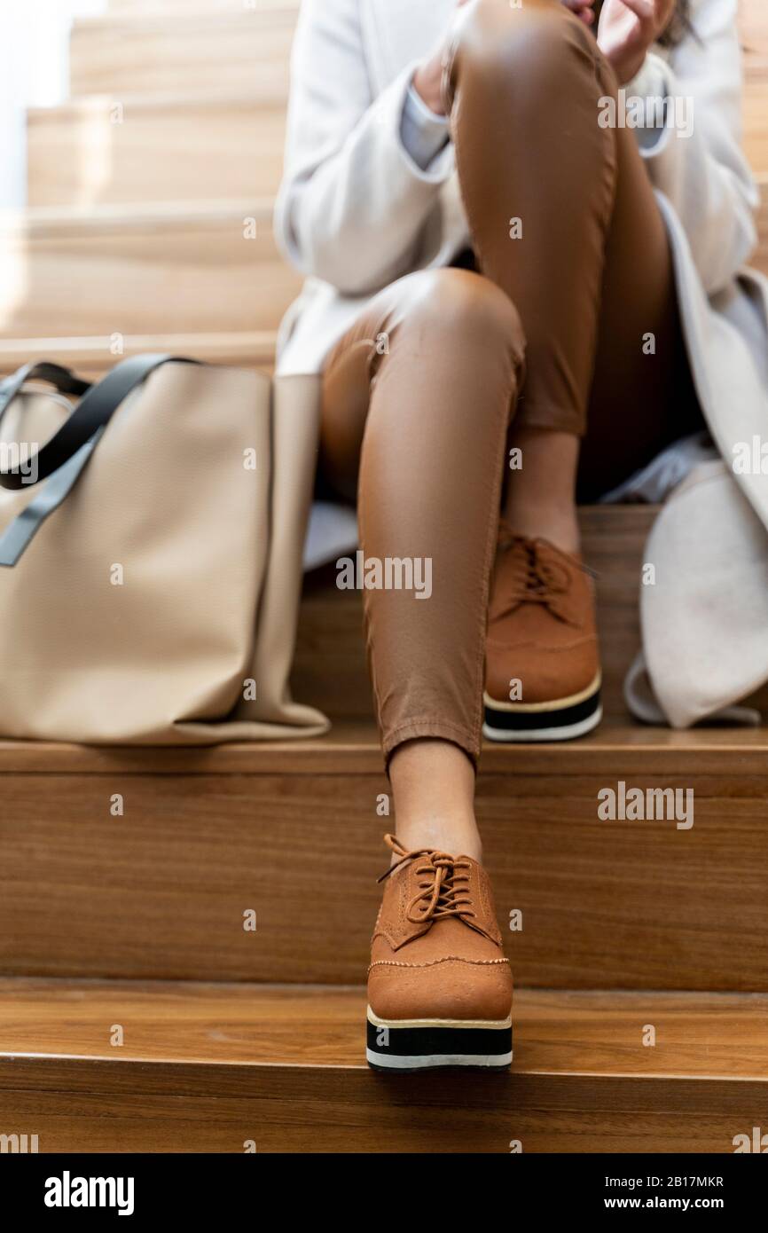 Low section of woman sitting on stairs Stock Photo - Alamy