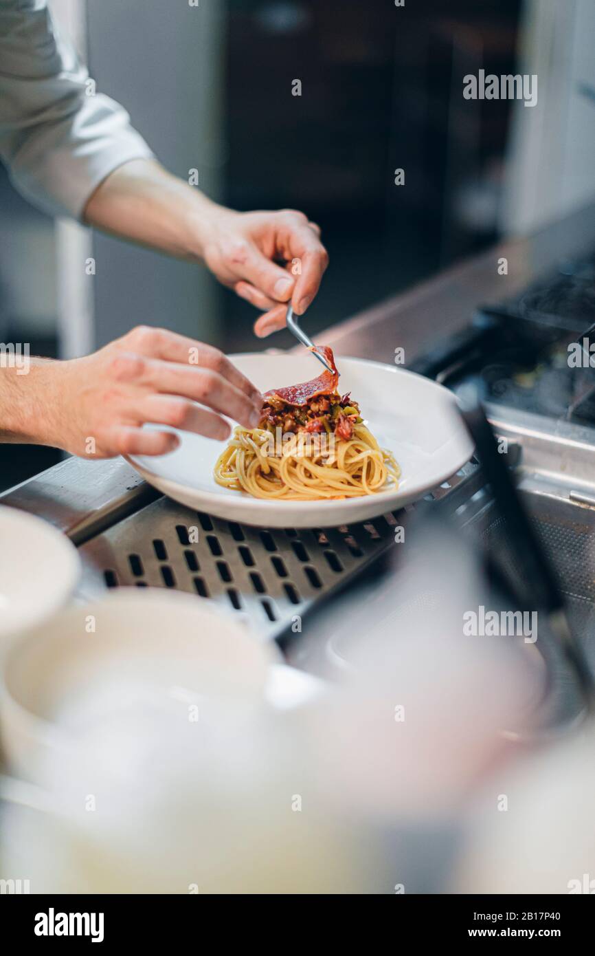 Chef preparing a dish in traditional Italian restaurant kitchen Stock ...