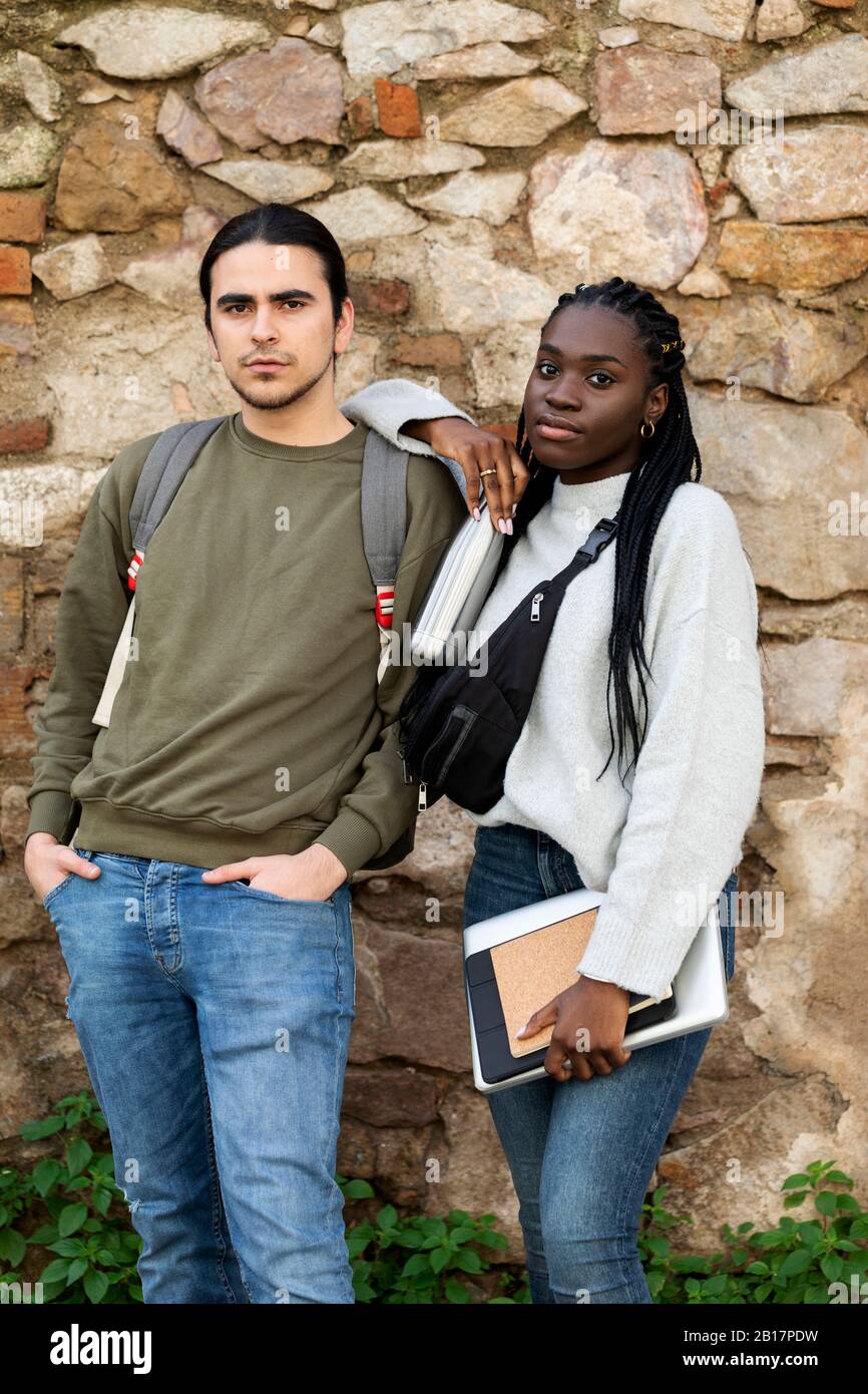 Portrait of a confident couple at a stone wall Stock Photo - Alamy