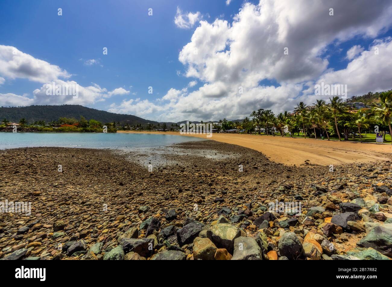 Australia, Queensland, Airlie Beach, Clouds over rocky coastal beach ...