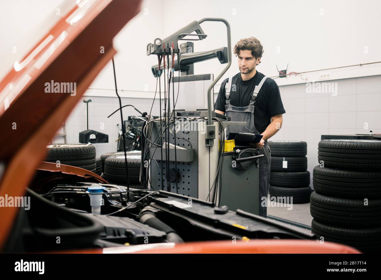 Car mechanic in a workshop using modern diagnostic equipment Stock ...
