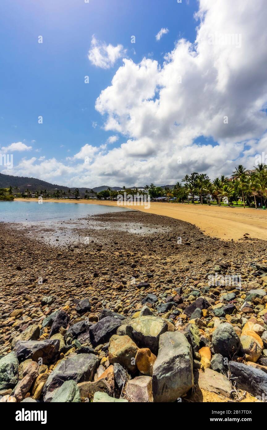 Australia, Queensland, Airlie Beach, Clouds over rocky coastal beach ...