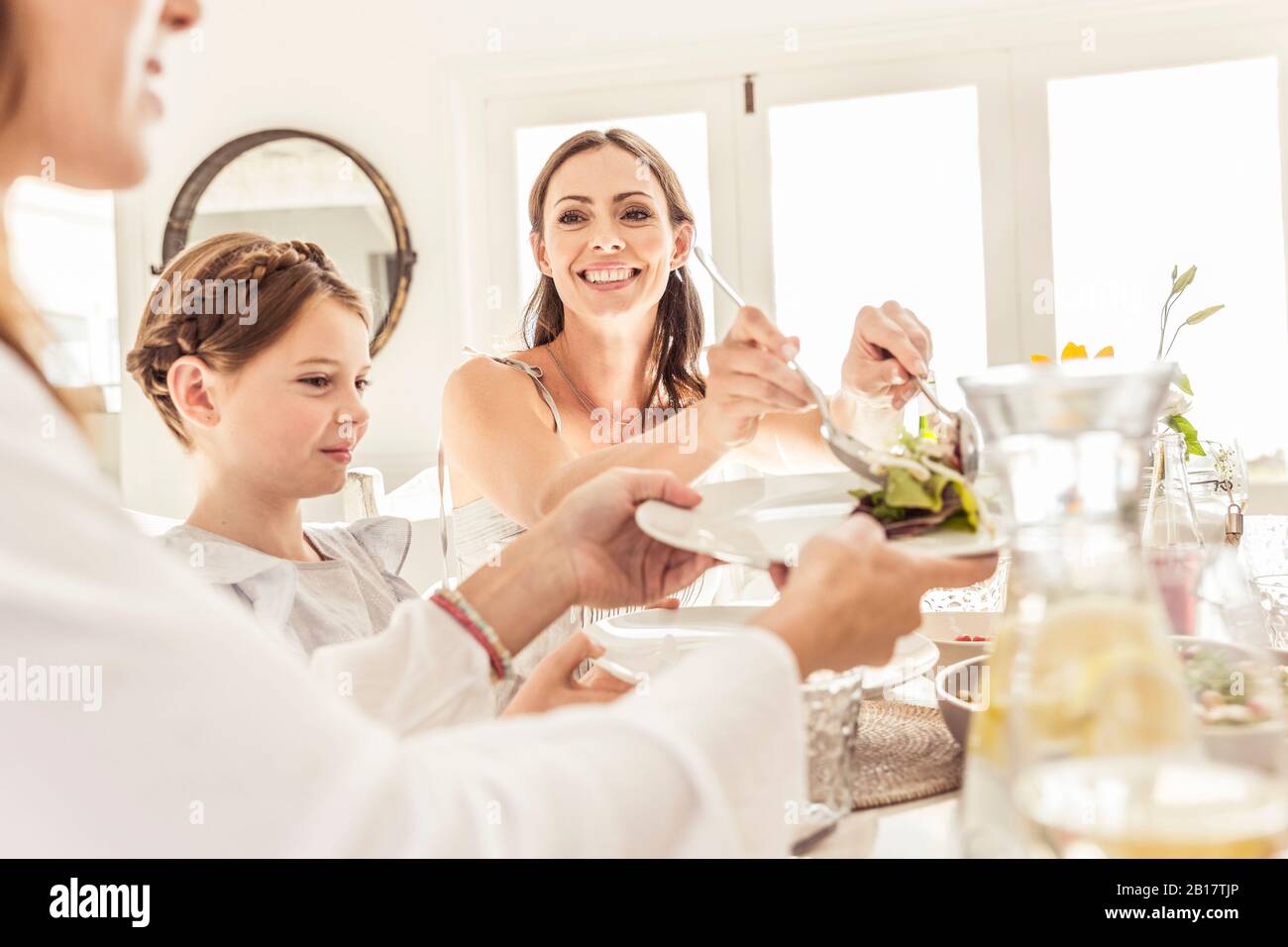 Girl and two women having lunch together Stock Photo - Alamy