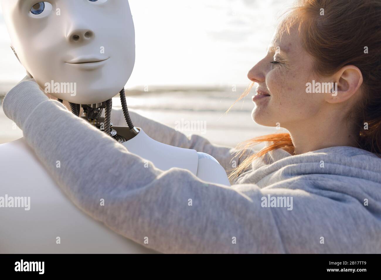 Happy woman embracing robot on the beach Stock Photo - Alamy