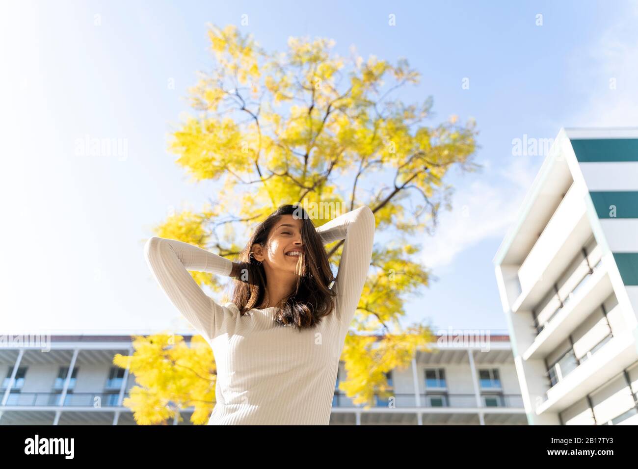 Happy young woman outdoors at a tree Stock Photo - Alamy