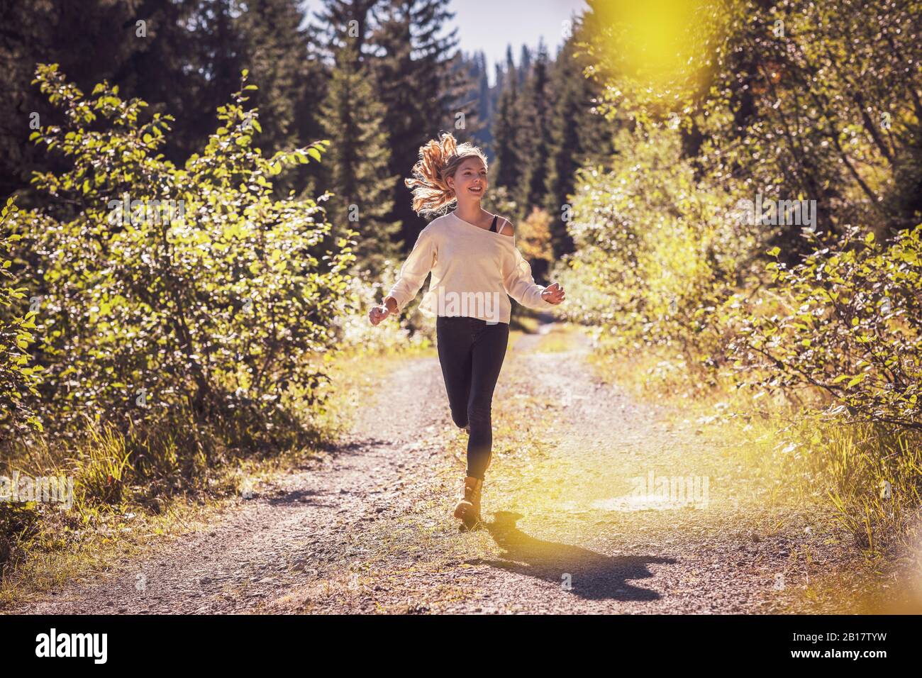 Girl running and jumping on a forest path, having fun Stock Photo - Alamy
