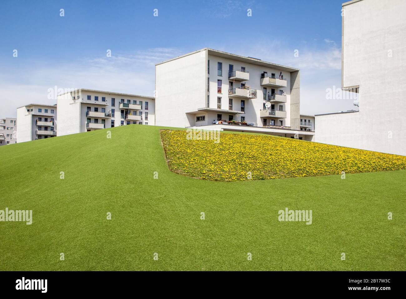 Germany, Bavaria, Munich, Green lawn in front of residential buildings ...