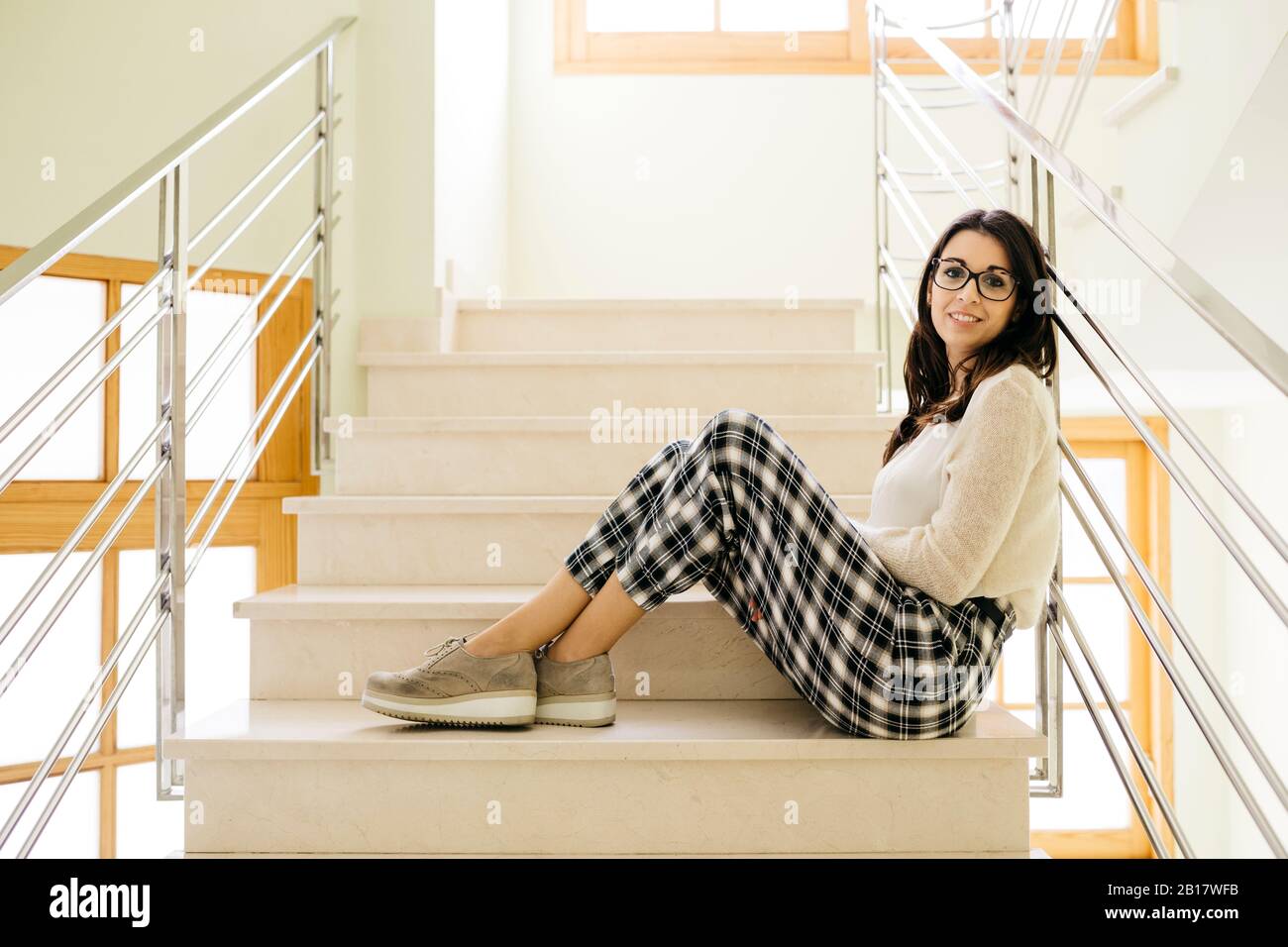 Woman sitting on stairwell hi-res stock photography and images - Alamy