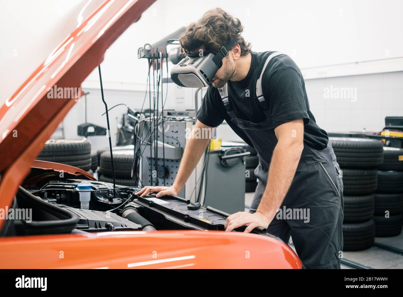 Car mechanic wearing VR glasses in a workshop working at car Stock ...