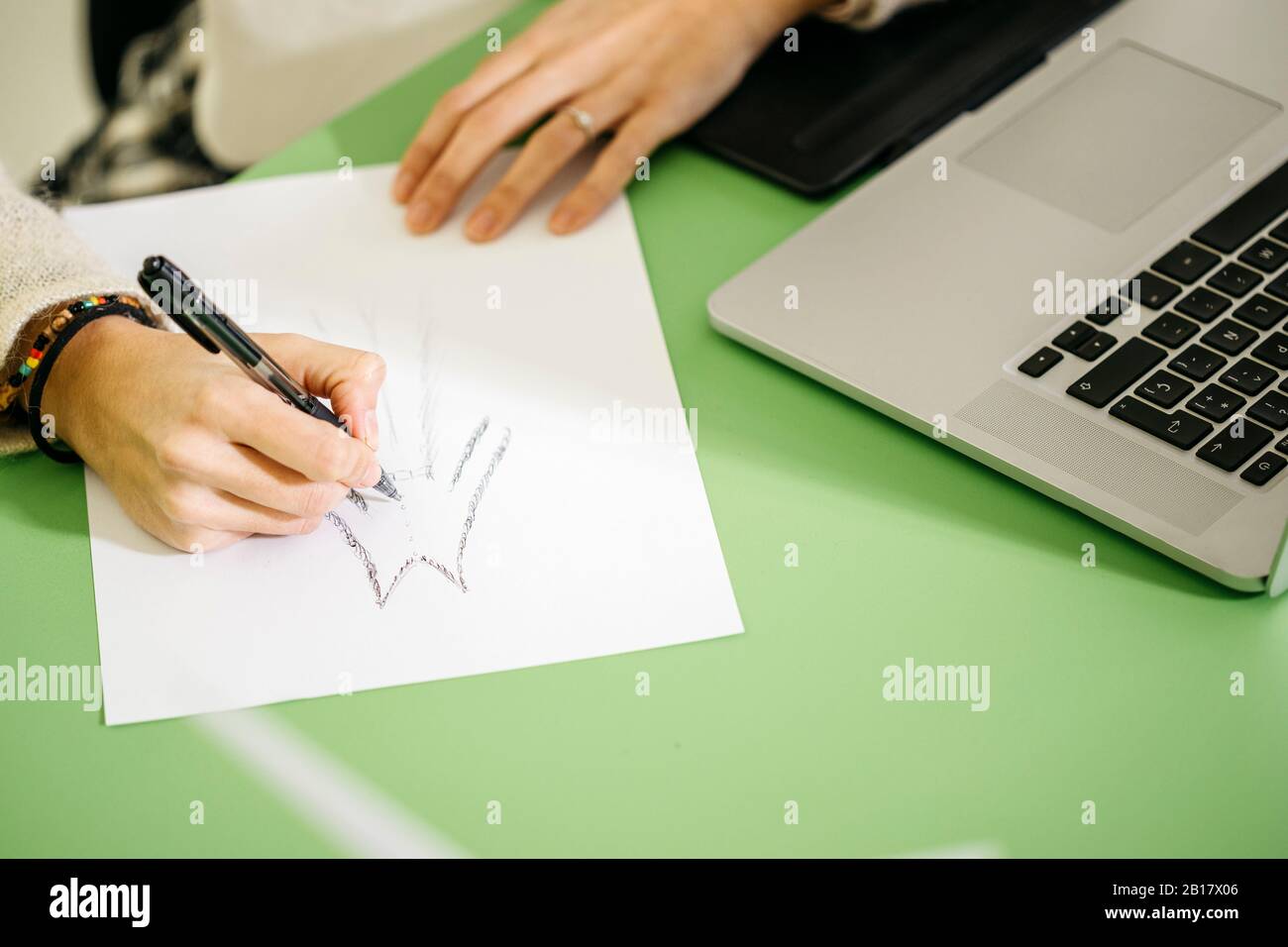 Close-up of woman at desk in office drawing on paper Stock Photo - Alamy