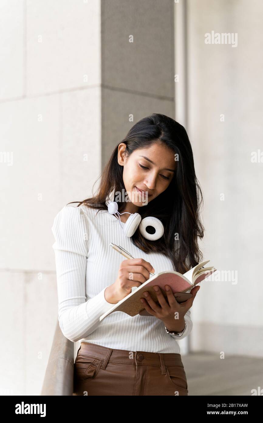 Young woman taking notes outdoors Stock Photo - Alamy