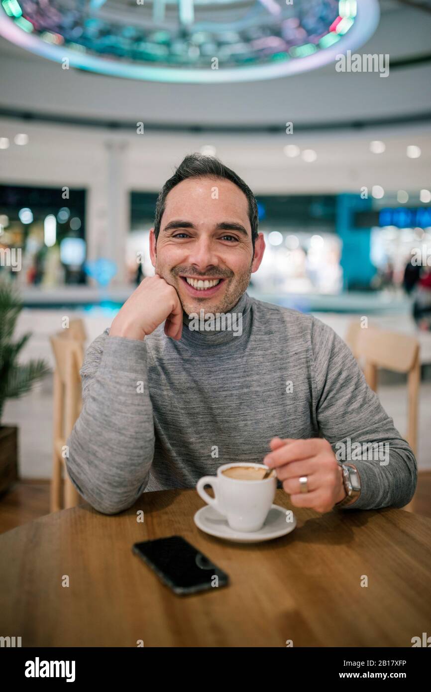 Man sitting in cafeteria, drinking coffee Stock Photo - Alamy