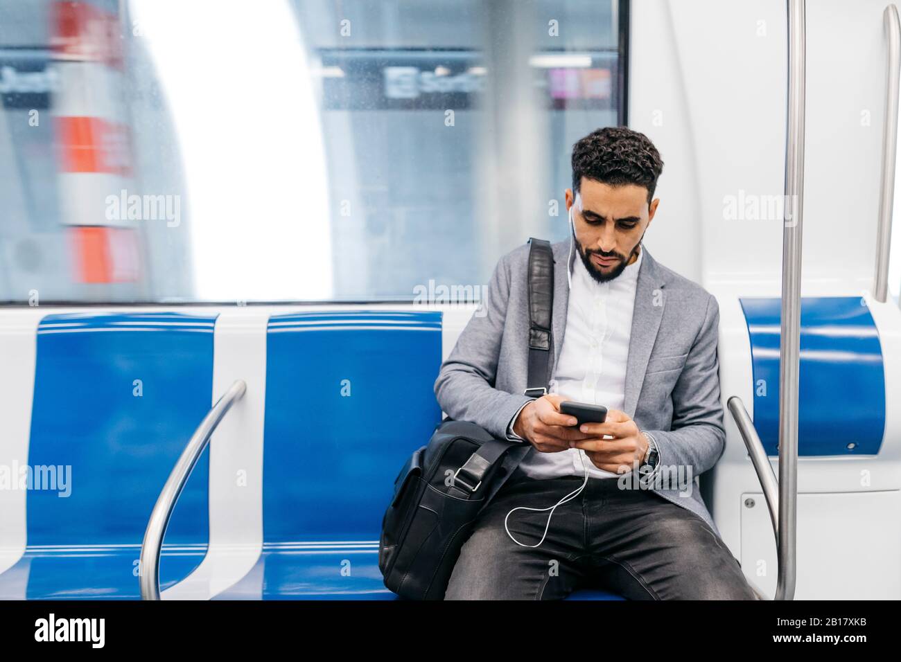 Train commuters looking at phones hi-res stock photography and images ...