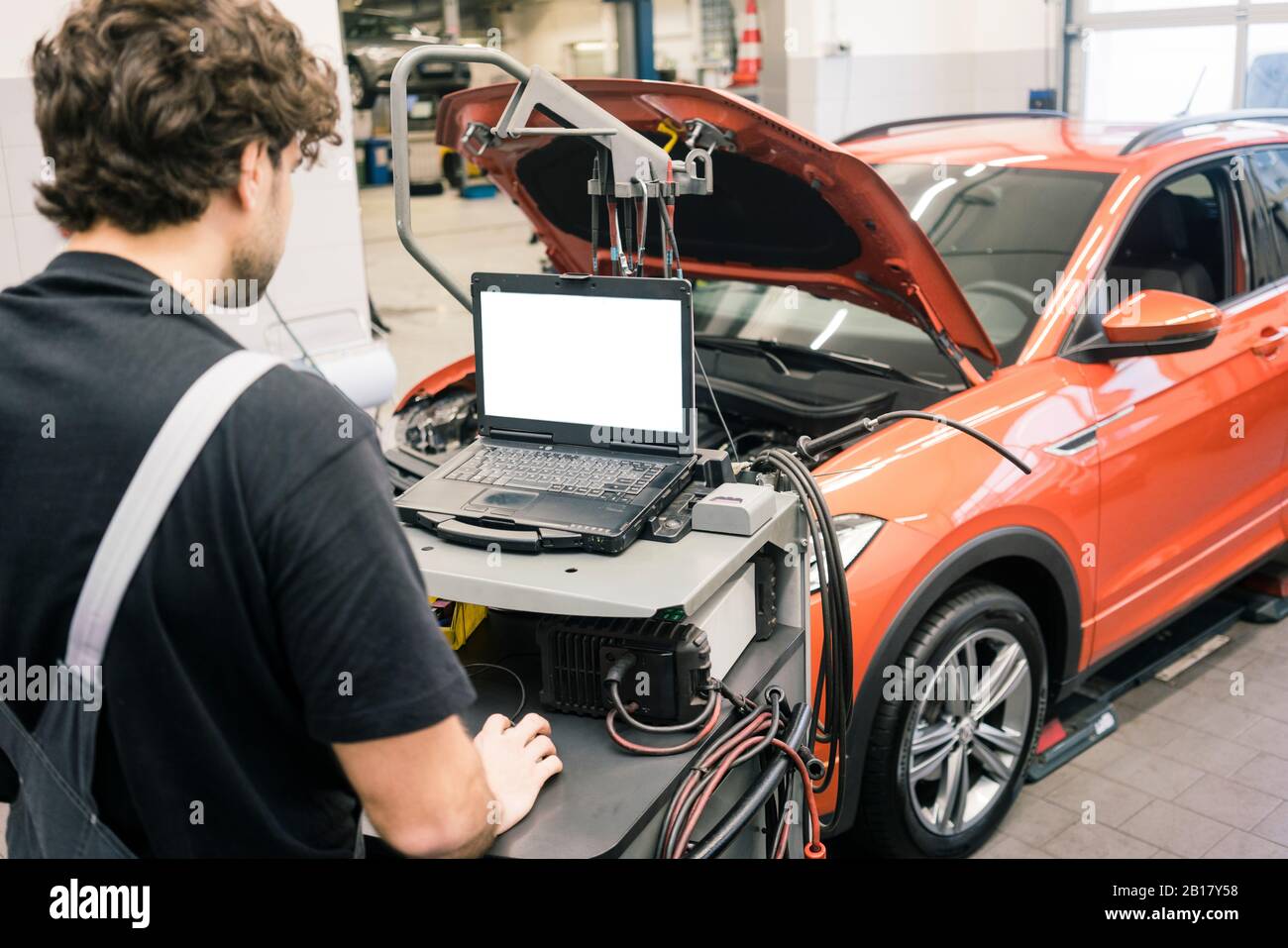 Car mechanic in a workshop using modern diagnostic equipment Stock ...