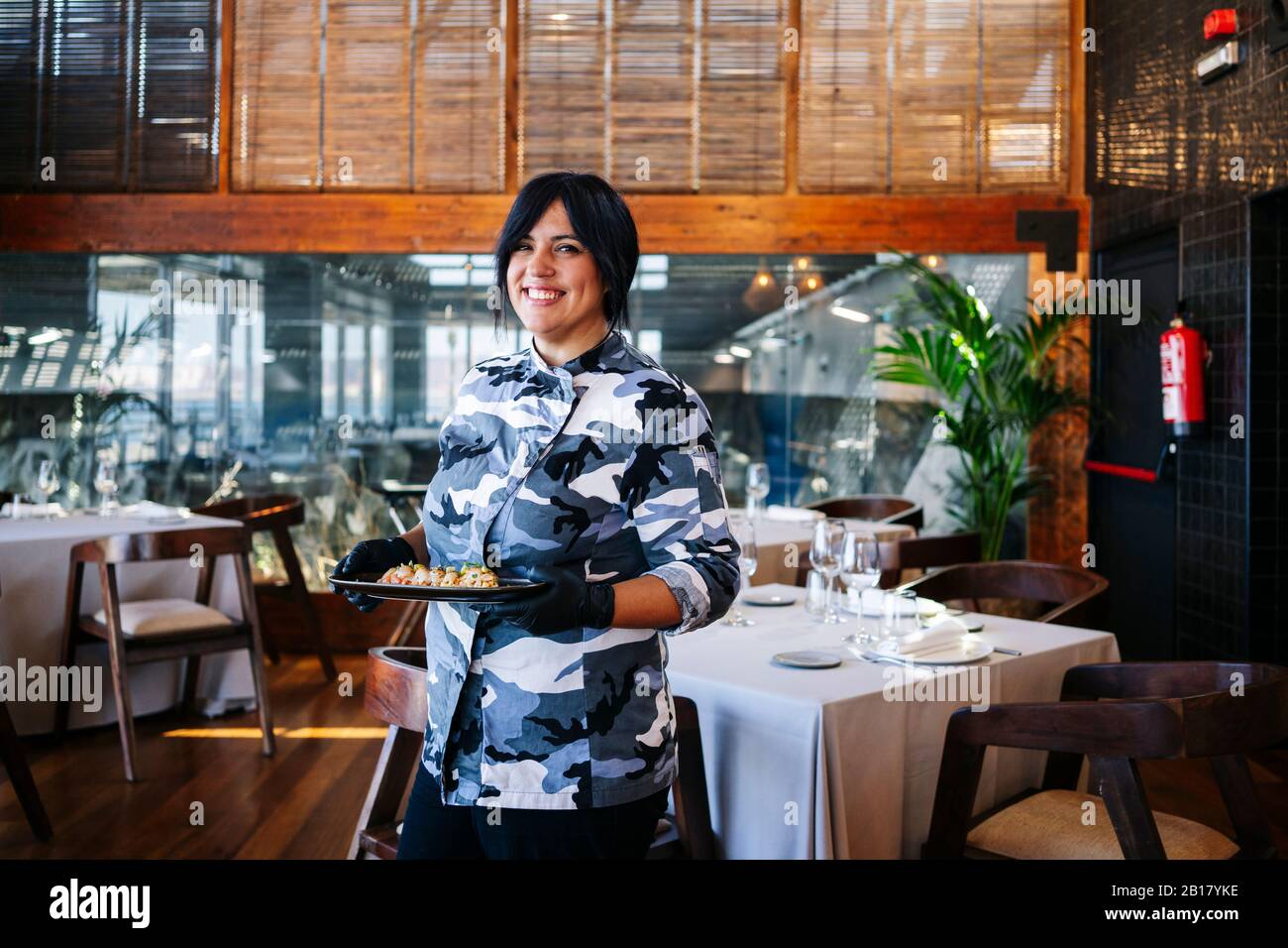Smiling female chef serving hi-res stock photography and images - Alamy