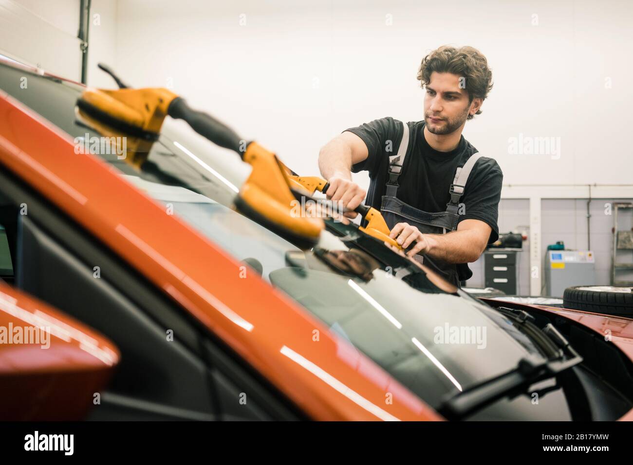 Car mechanic in a workshop changing car window Stock Photo - Alamy