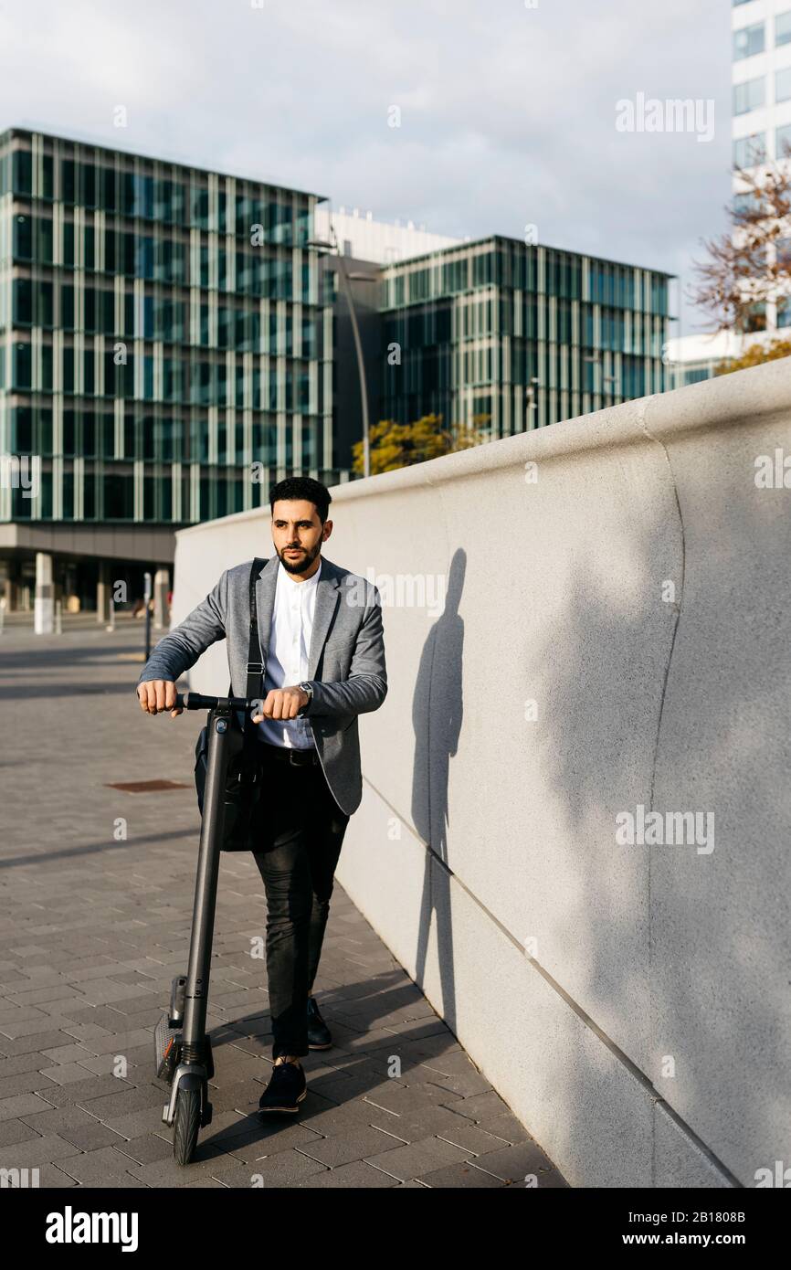 Pushing his e scooter hi-res stock photography and images - Alamy
