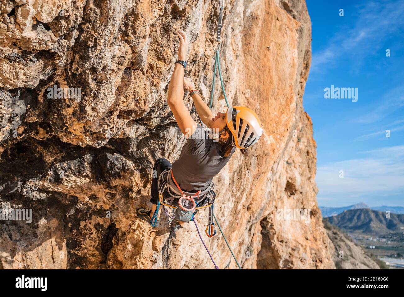 Woman climbing at rock face Stock Photo - Alamy