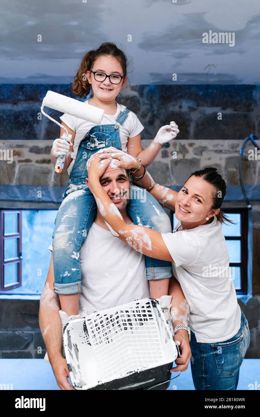 Family having fun while painting a wall of her new house Stock Photo ...