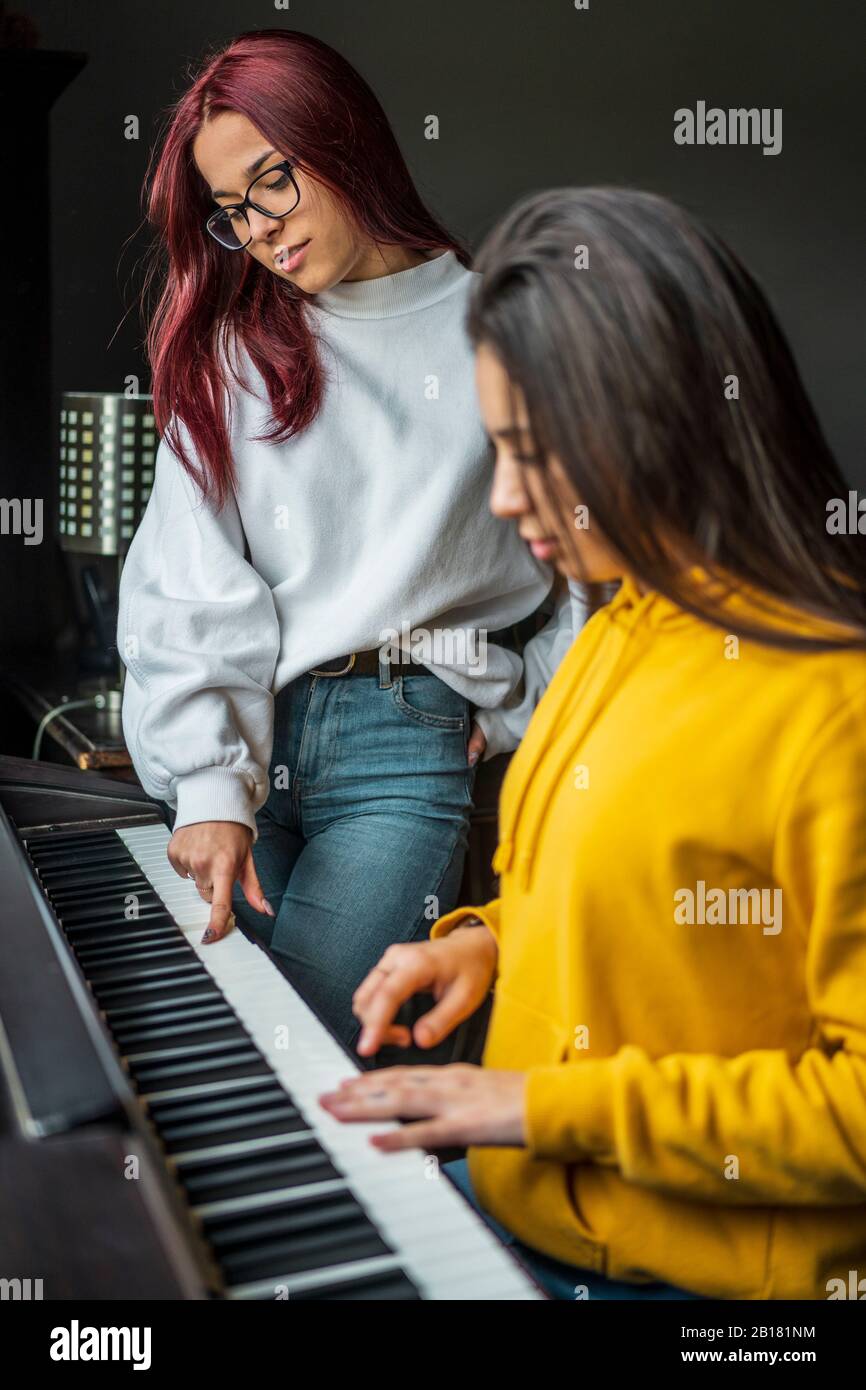 Two teenage girls practicing piano Stock Photo - Alamy
