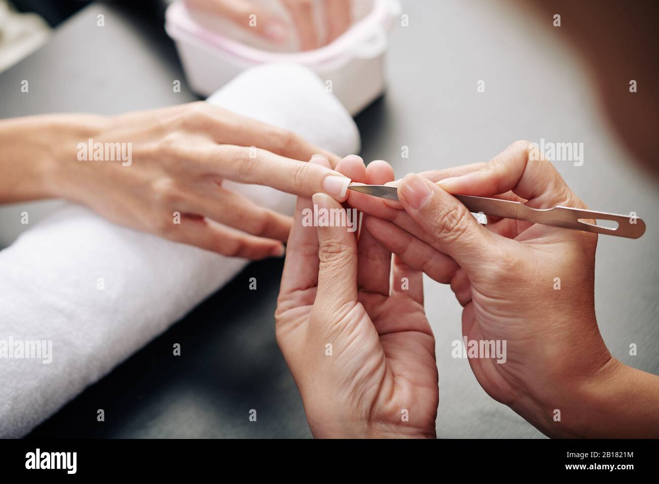 Process of manicurist cleaning dirt from under nails of client with ...