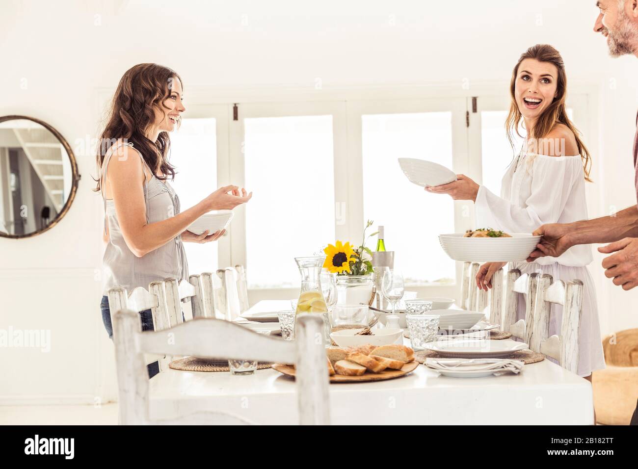 Family and friends setting the table for lunch Stock Photo - Alamy