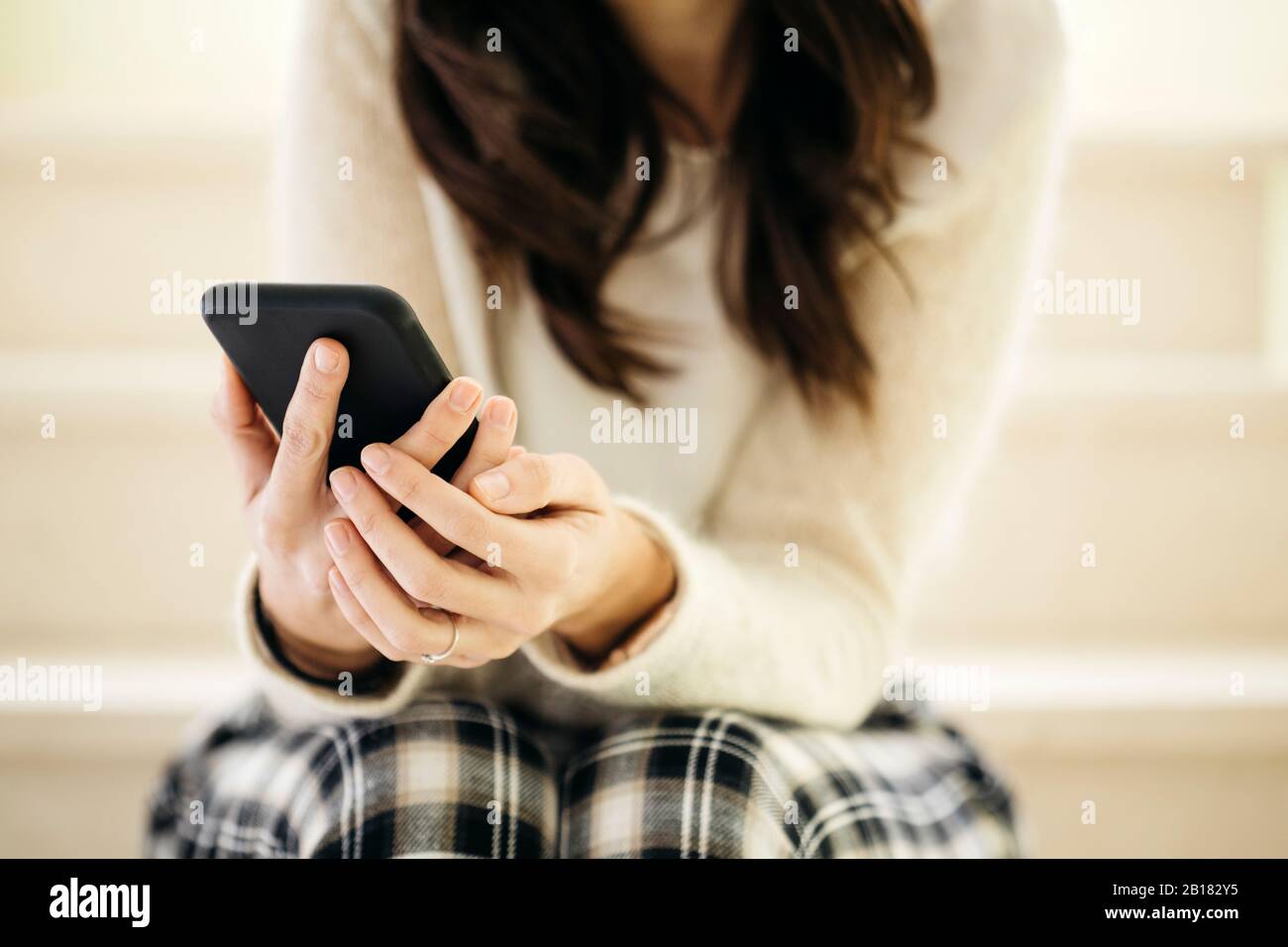 Close-up of woman sitting on stairs holding cell phone Stock Photo - Alamy