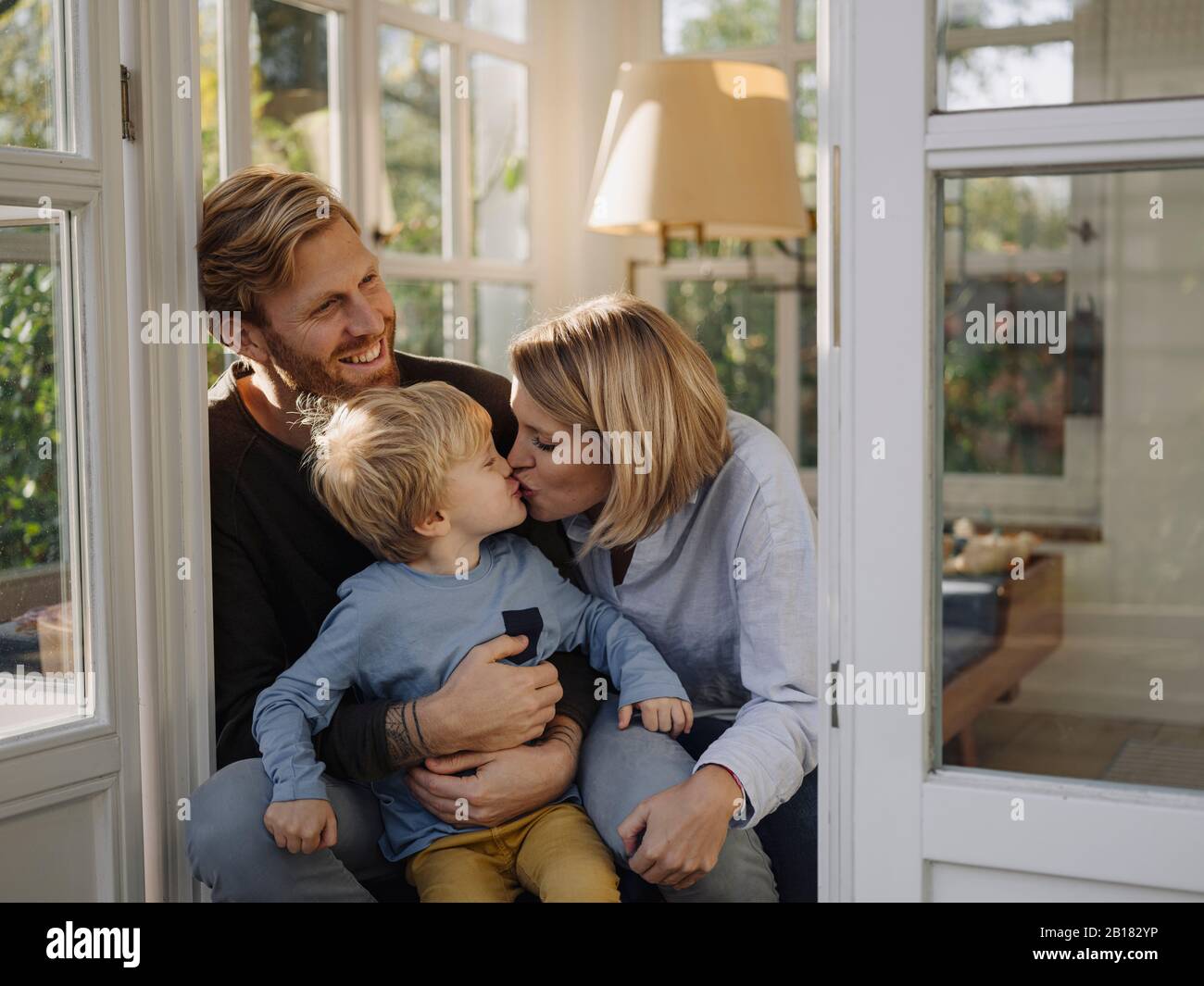 Happy and affectionate family in sunroom at home Stock Photo - Alamy