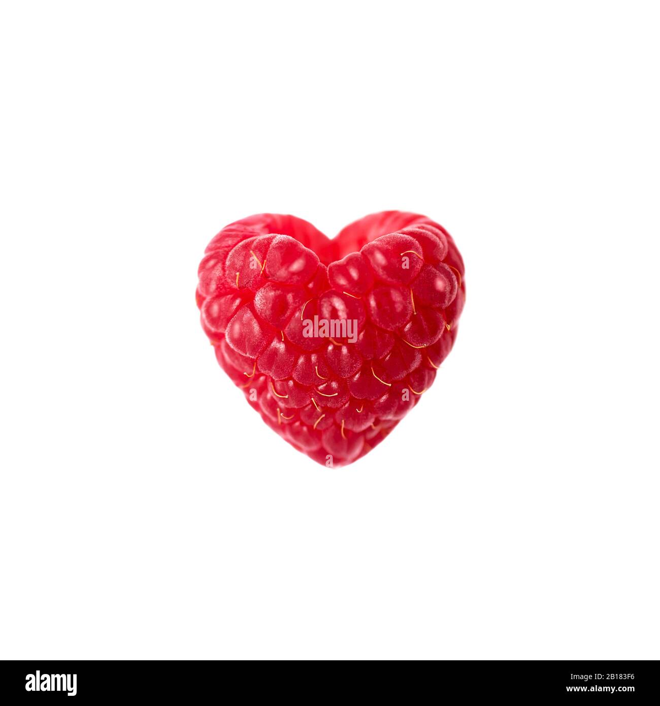 Raspberry in the shape of a heart with a shadow on a white background ...