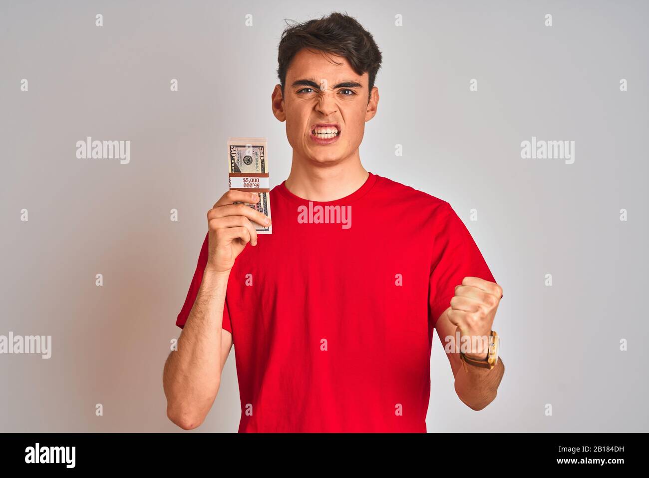 Teenager boy holding a bunch of dollars bank notes over isolated ...