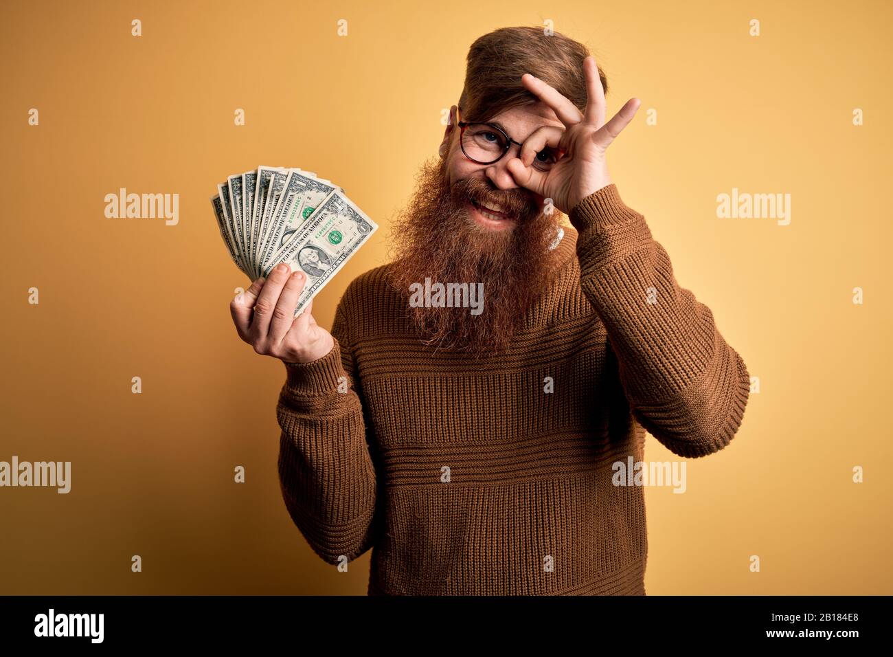Redhead Irish man with beard holding a bunch of 1 dolla banknotes over ...