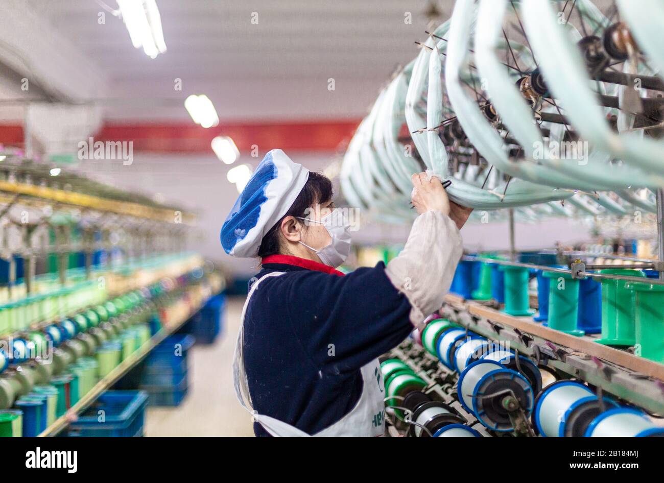 A female Chinese worker deals with production of silk at the plant of ...