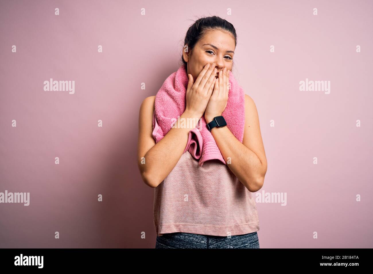 Young beautiful brunette sportswoman wearing sportswear and towel over ...