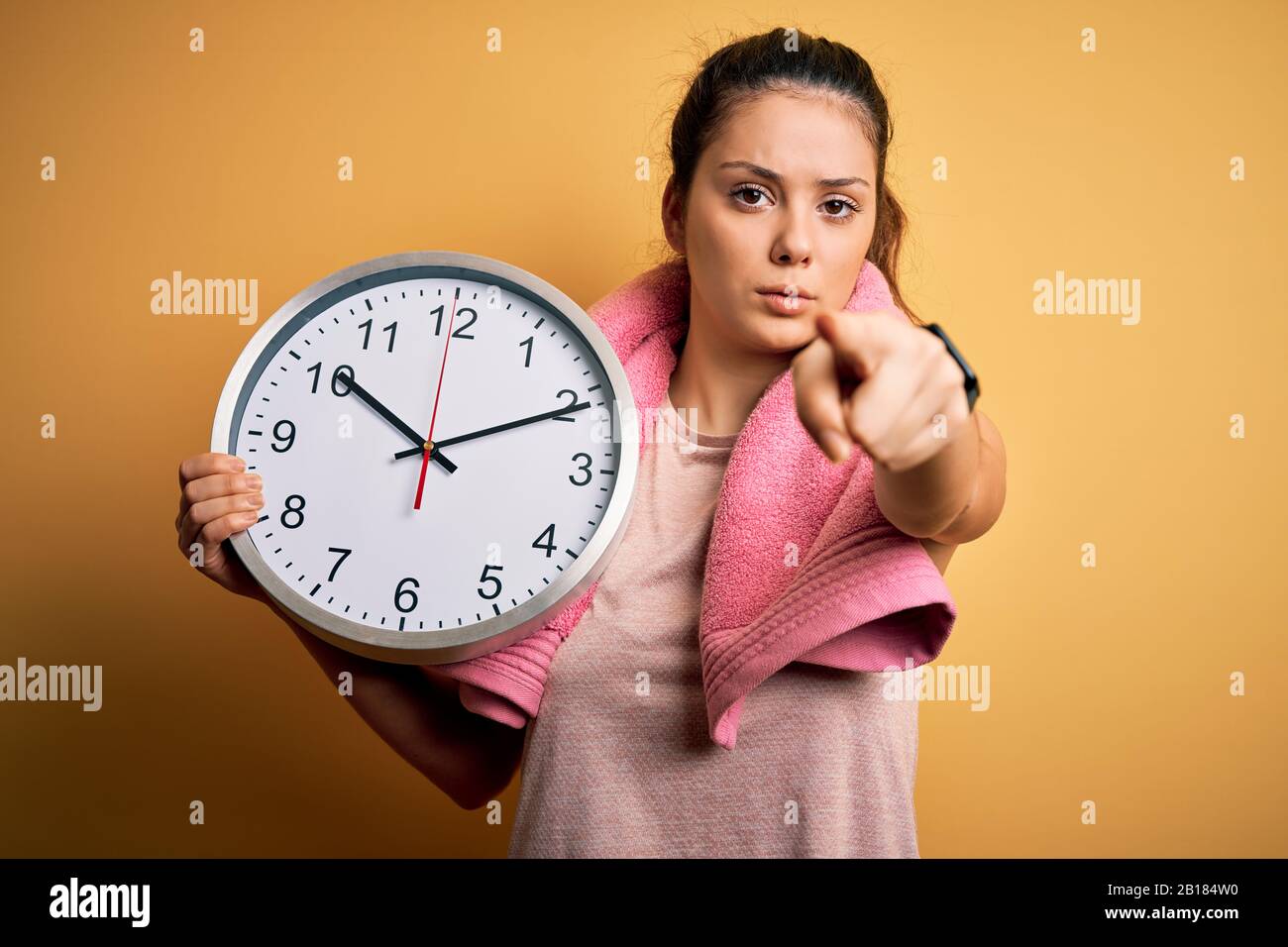 Young beautiful brunette sportswoman wearing towel doing countdown ...