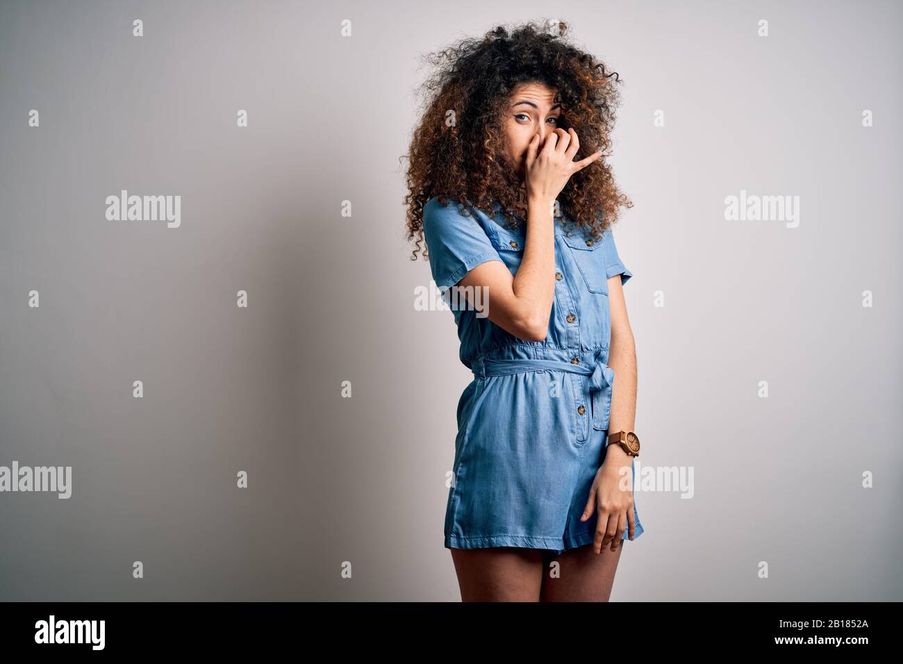 Young beautiful woman with curly hair and piercing wearing casual denim ...
