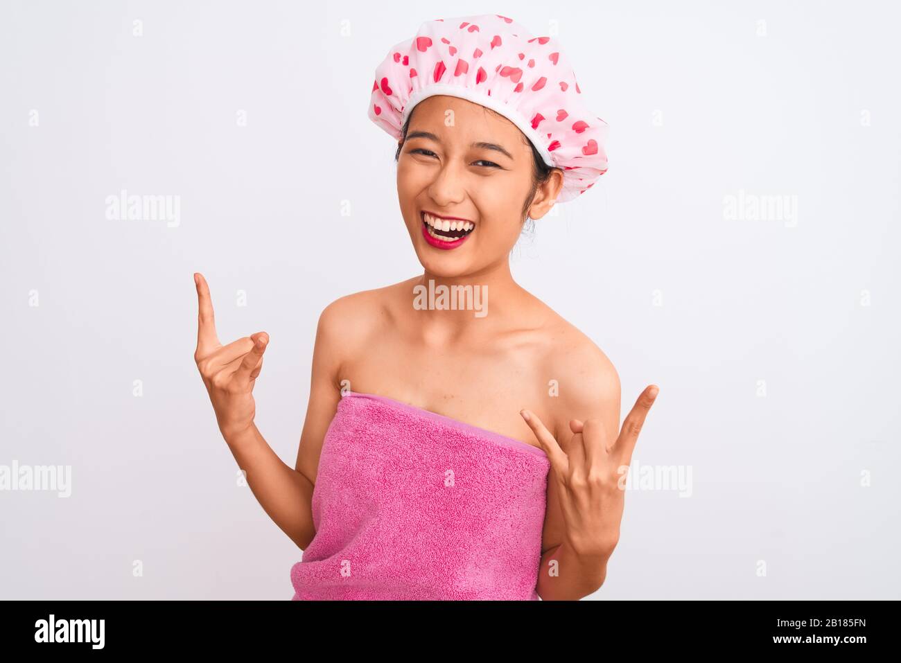 Young chinese woman wearing shower towel and cap bath over isolated ...