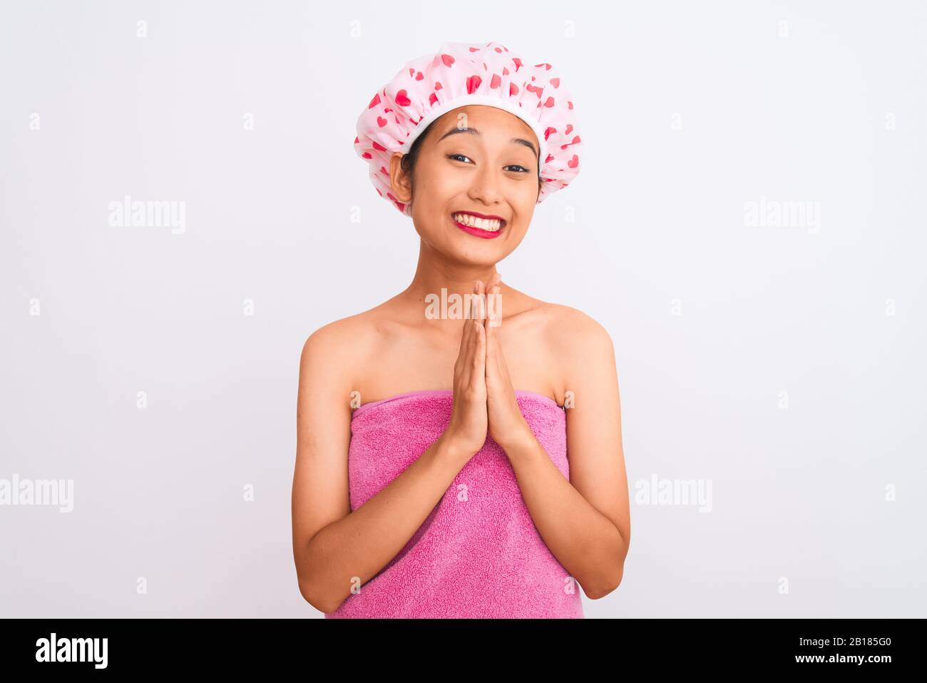 Young chinese woman wearing shower towel and cap bath over isolated ...