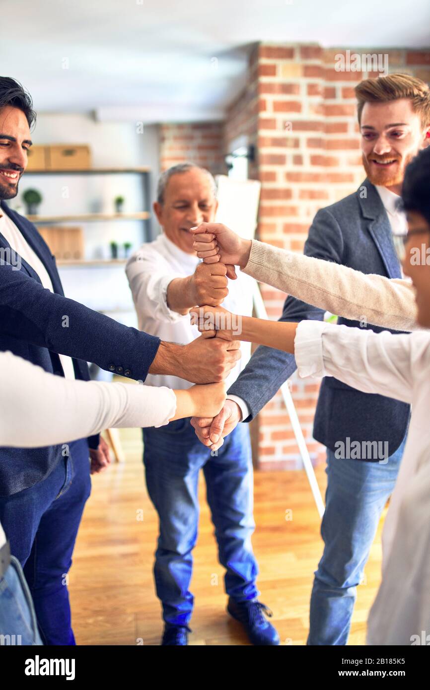 Group of business workers smiling happy. Standing bumping fists at the ...