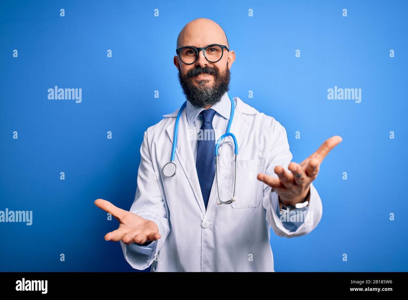 Handsome bald doctor man with beard wearing glasses and stethoscope ...