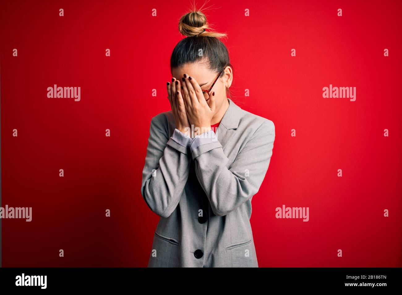 Young beautiful blonde businesswoman with blue eyes wearing glasses and ...