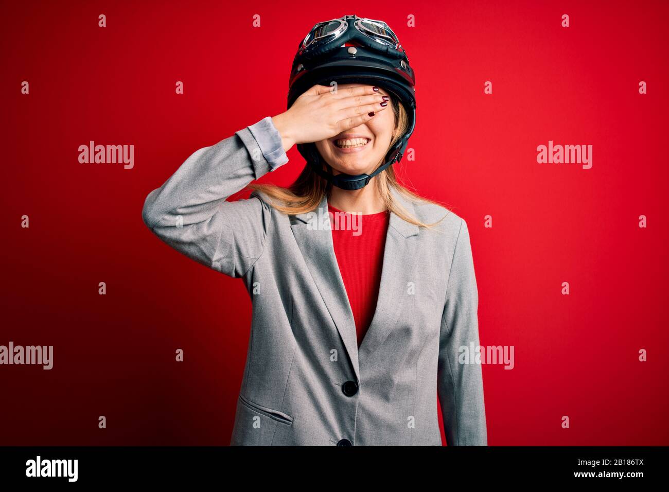 Young beautiful blonde motorcyclist woman wearing motorcycle helmet ...