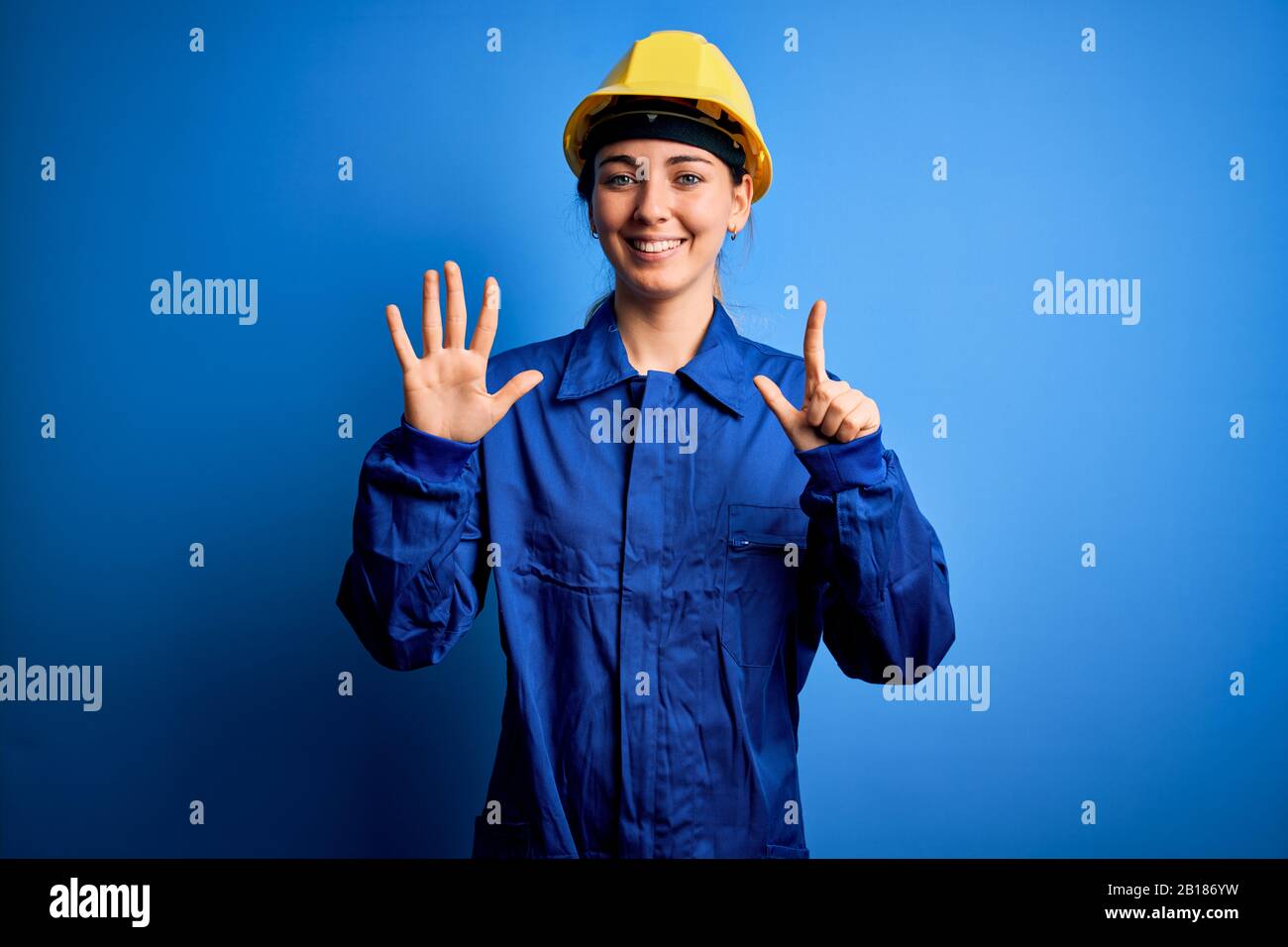 Young Beautiful Worker Woman With Blue Eyes Wearing Security Helmet And