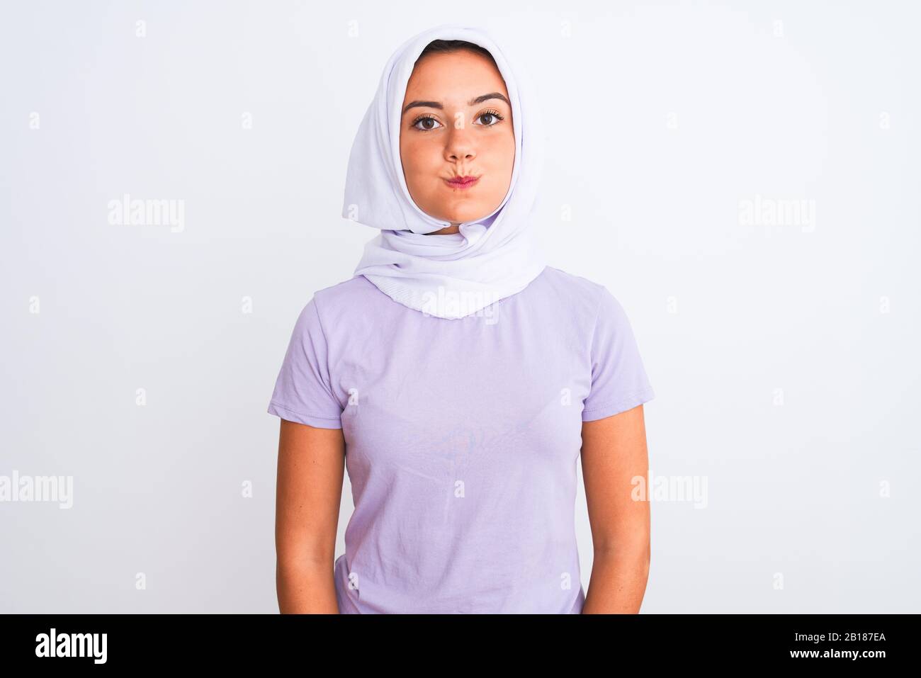 Young beautiful arabian girl wearing hijab standing over isolated white ...