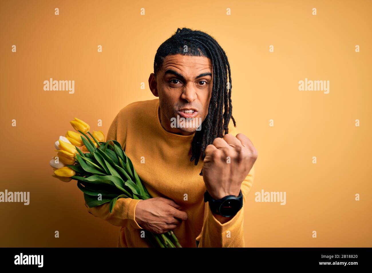 Young african american afro romantic man with dreadlocks holding ...