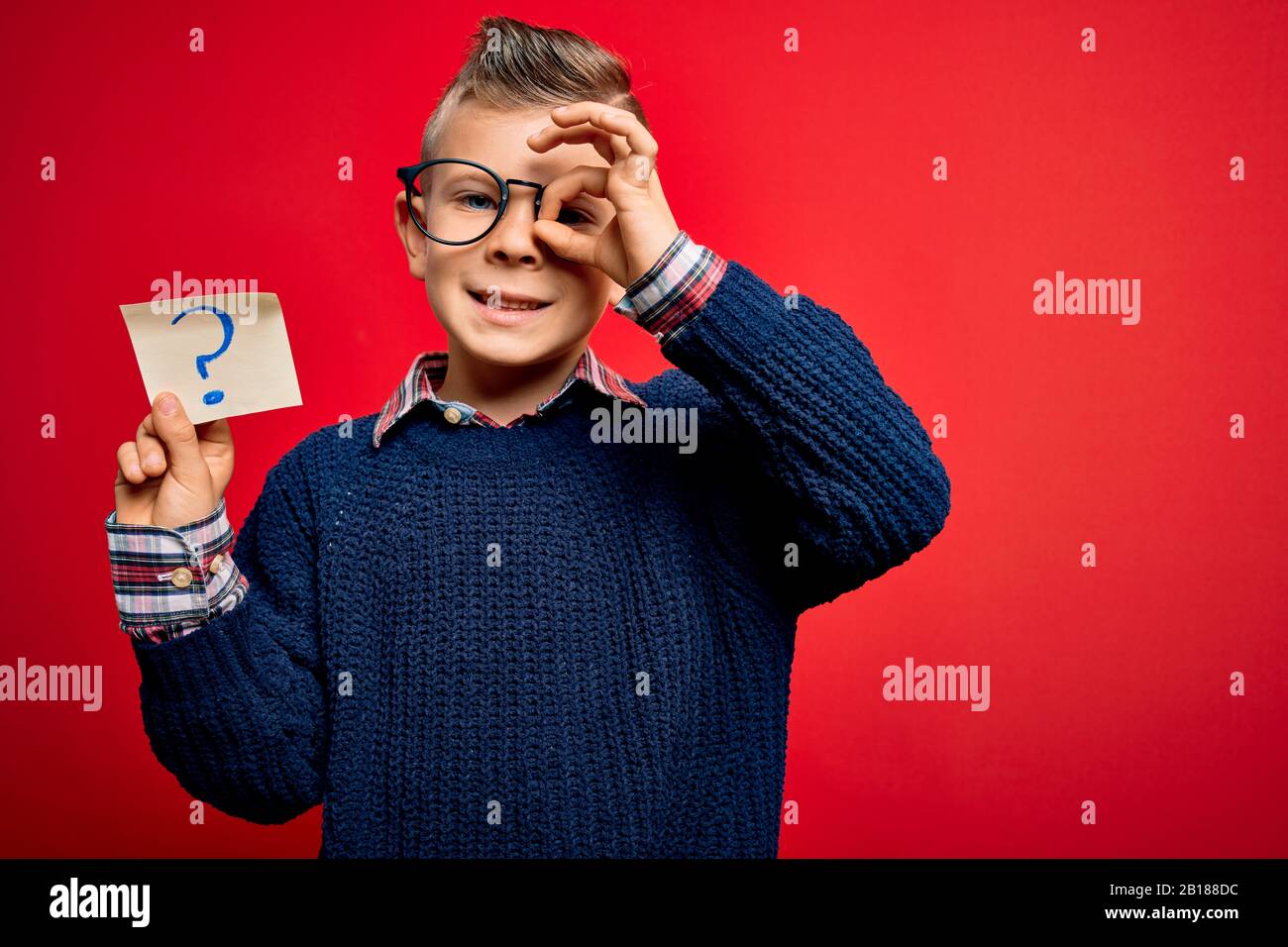 Young little caucasian kid wearing glasses holding paper note with ...