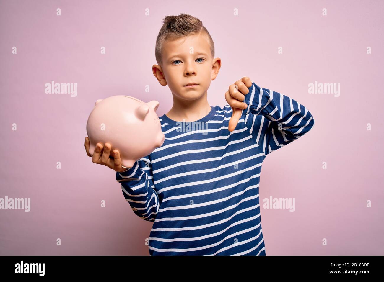 Young little caucasian kid banking money on piggy bank as wealth ...