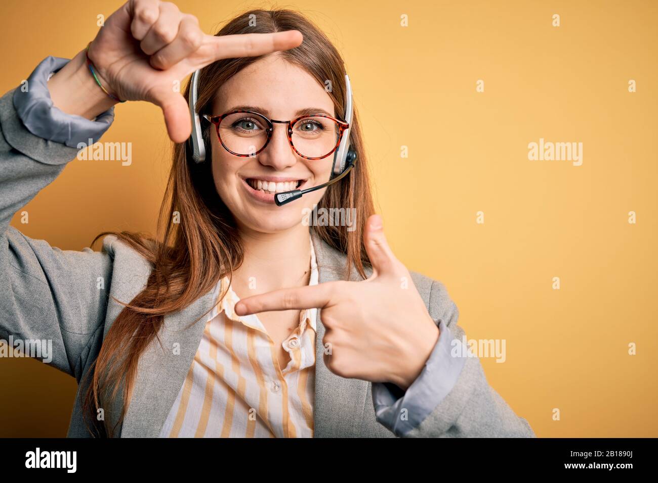 Young redhead call center agent woman overworked wearing glasses using ...