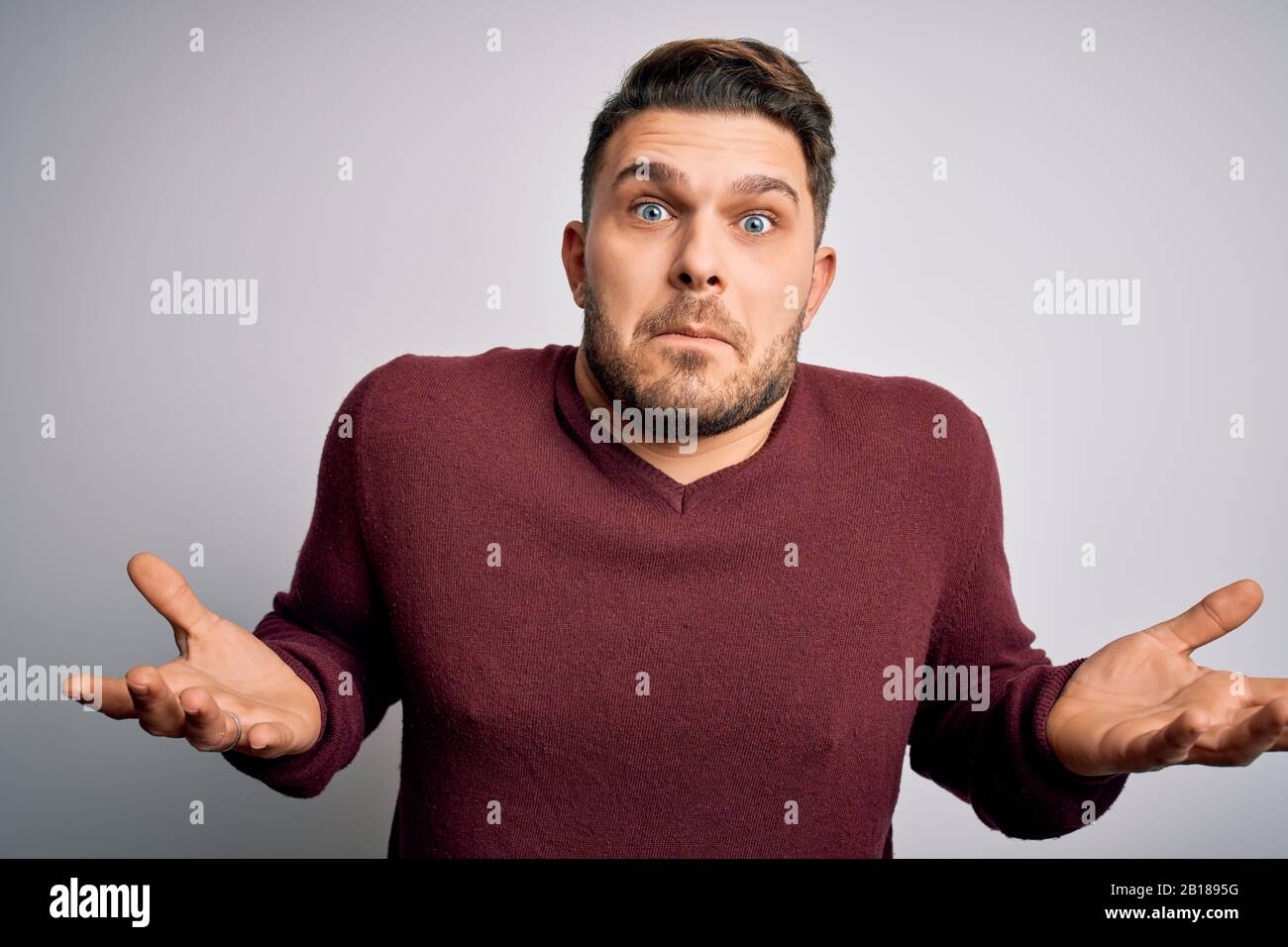 Young man with blue eyes wearing casual sweater standing over isolated ...